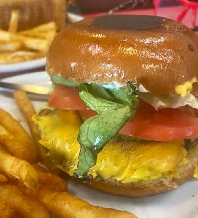 Behold the cheeseburger in its natural habitat—perfectly melted cheese cascading down a hand-patted patty like a yellow waterfall of deliciousness.