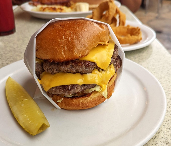 This isn't just a cheeseburger – it's a monument to beef architecture, with cheese cascading like a yellow waterfall of deliciousness.