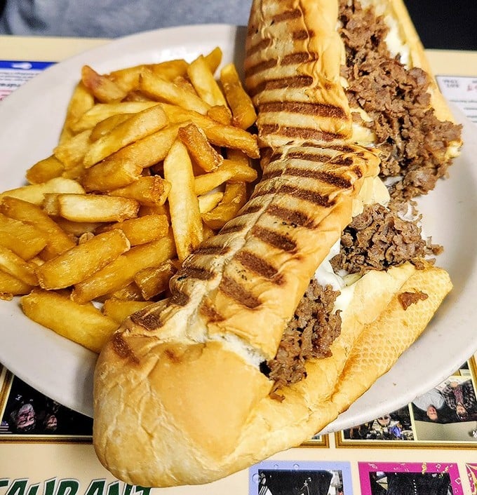 The cheesesteak sandwich—where golden fries and perfectly grilled beef create the kind of lunch that demands a post-meal nap.