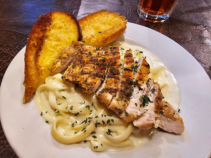 Grilled chicken resting on a cloud of alfredo pasta – proof that sometimes the classics endure because they're simply unbeatable.