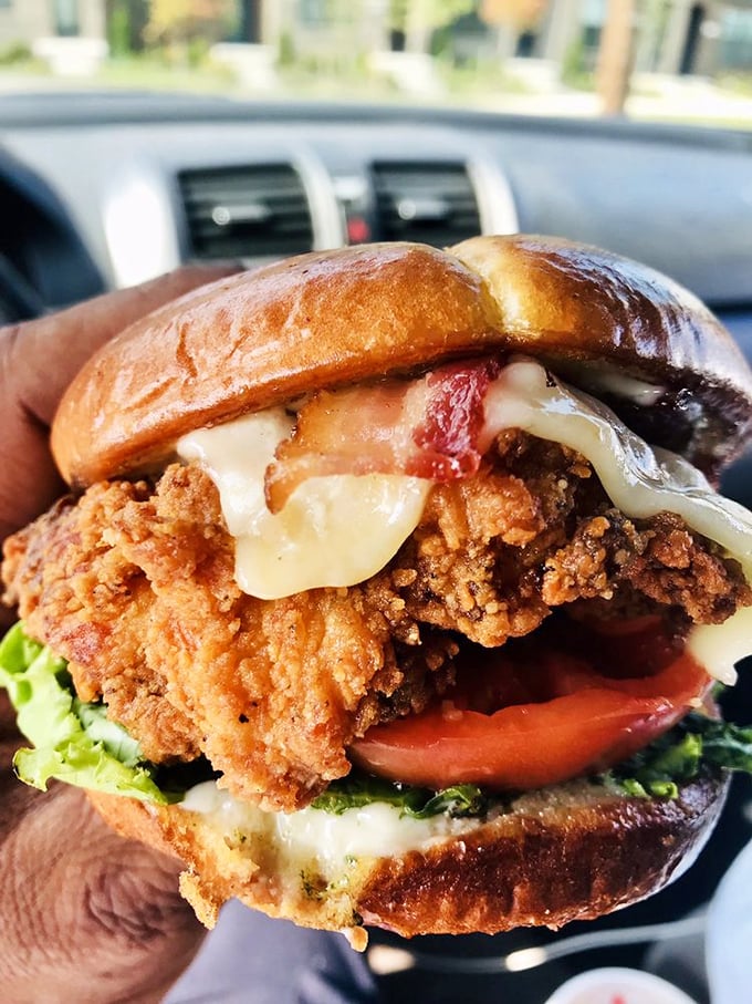This isn't just a sandwich; it's an architectural masterpiece where crispy chicken, melty cheese, and fresh veggies find harmony between a pillowy brioche bun.