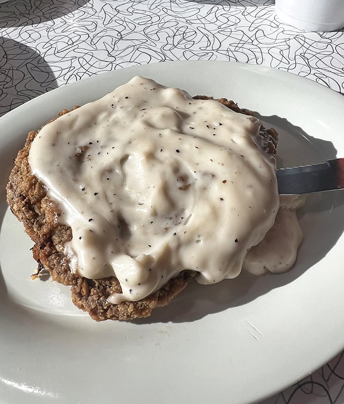 Country-fried steak swimming in pepper-flecked gravy – where "portion control" means you might need to control yourself from licking the plate.