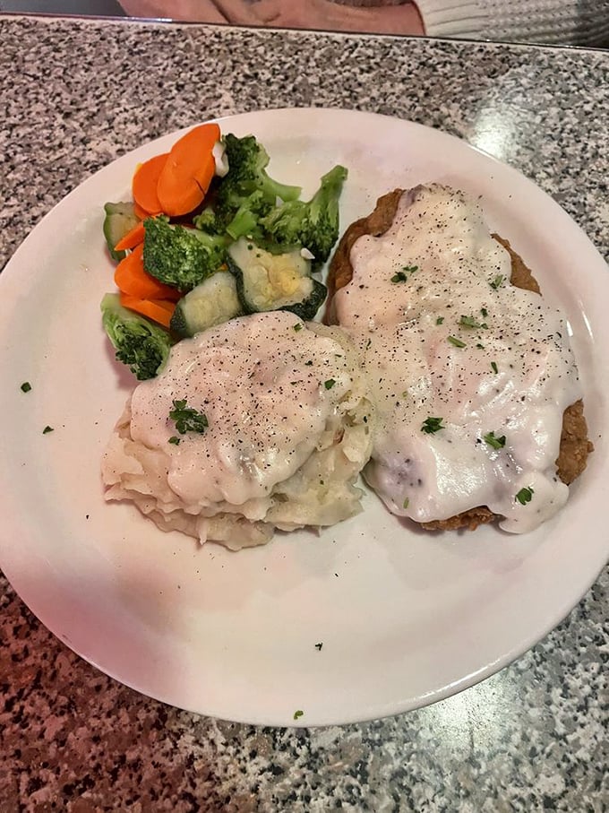 The chicken fried steak arrives like a crispy island in a sea of creamy gravy – a testament to the diner's mastery of comfort classics.