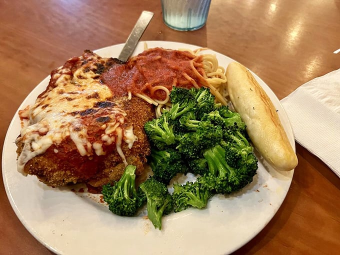 Chicken Parmesan that doesn't know the meaning of "portion control." Golden-brown cutlet, vibrant marinara, melted cheese, and a side of broccoli pretending this is a balanced meal.