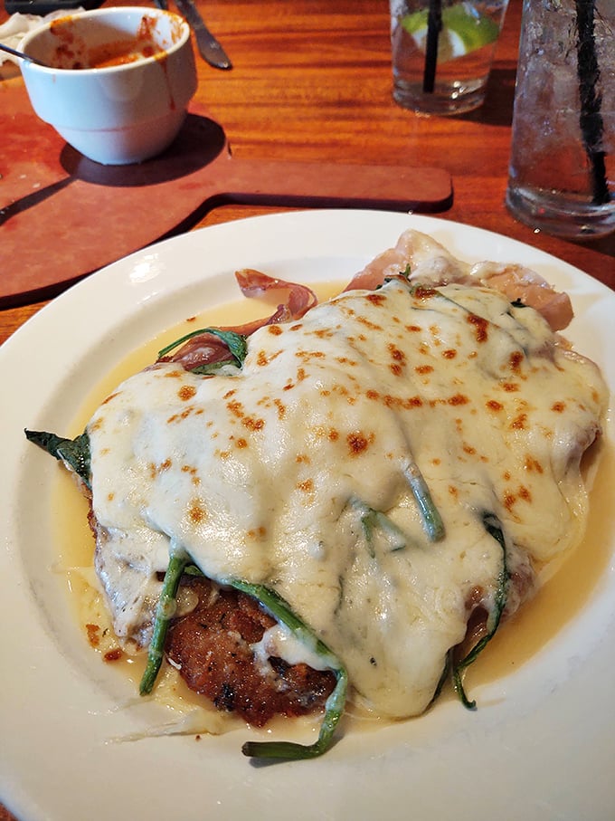 This chicken parmigiana isn't just covered in cheese—it's wearing a melted masterpiece like it's walking the red carpet of Italian-American cuisine.