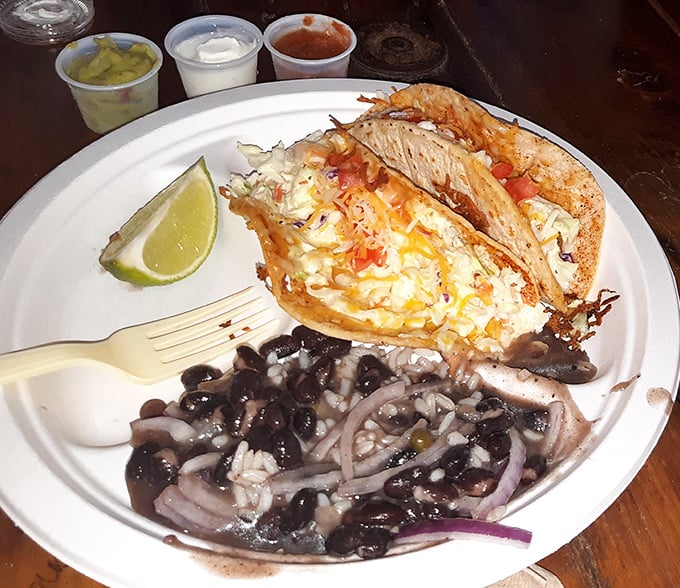 Fish tacos and black beans—a plate that screams "vacation" louder than your Hawaiian shirt. The lime isn't optional, it's essential.