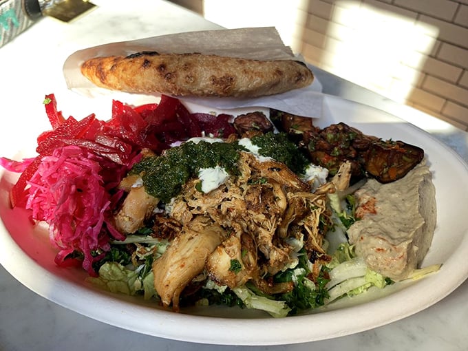 Chicken shawarma that would make your Mediterranean grandmother nod in approval—tender, aromatic, and nestled among a garden of fresh accompaniments.