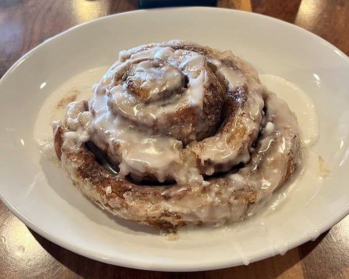 This isn't just a cinnamon roll—it's a spiral-bound love letter to morning indulgence. Pillowy dough, cinnamon swirls, and cream cheese glaze creating breakfast nirvana.