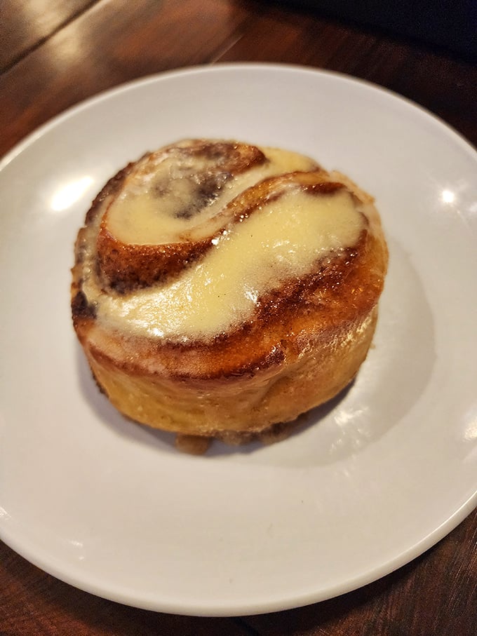 The humble cinnamon roll, elevated to art form – a spiral of buttery promise that makes Monday mornings significantly less offensive.