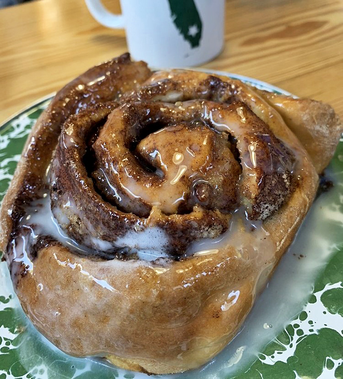This cinnamon roll isn't playing around—it's the heavyweight champion of breakfast indulgence, glistening with enough glaze to make your dentist wince.
