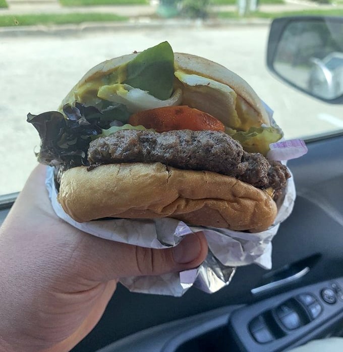 The classic burger in its natural habitat—wrapped in paper, enjoyed in a car. Some of life's greatest pleasures require no fancy setting.