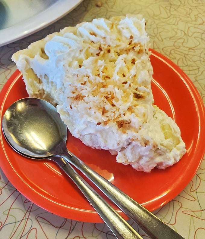 Coconut cream pie so tall and proud it deserves its own zip code. That toasted coconut sprinkle isn't garnish—it's the crown jewels.