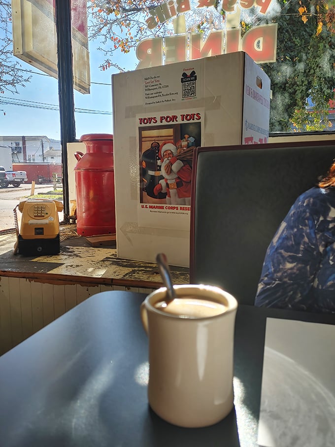 That classic white mug isn't just holding coffee—it's cradling liquid optimism while Toys for Tots reminds you this place has heart.