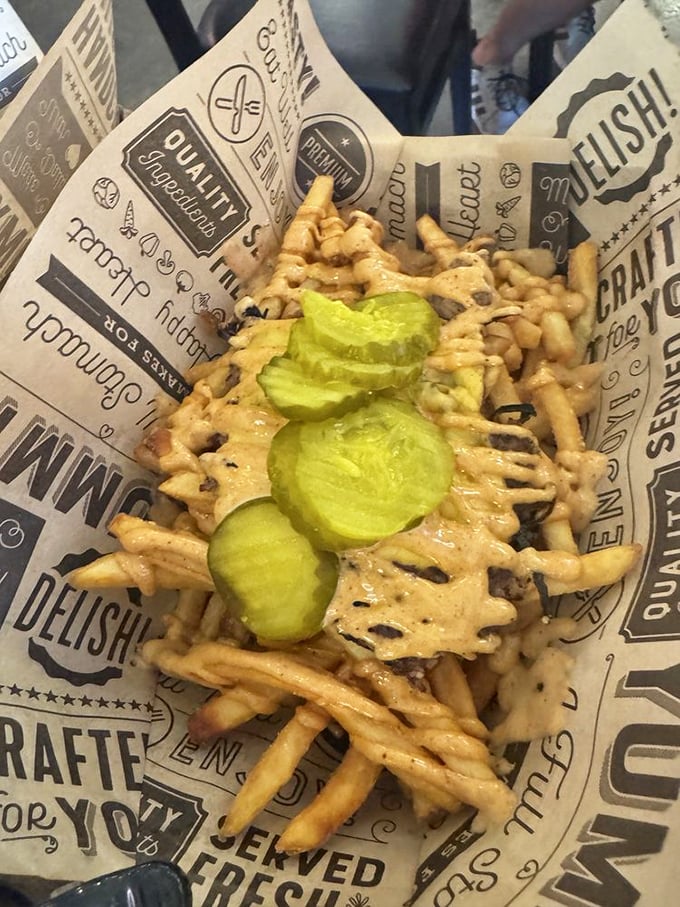 These loaded fries aren't just a side dish—they're a main event, with pickles standing at attention like tiny green sentinels of tang.