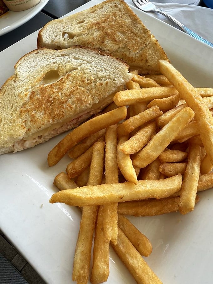The humble crab sandwich elevated to art form—crispy bread embracing what appears to be the day's freshest catch and perfect fries.