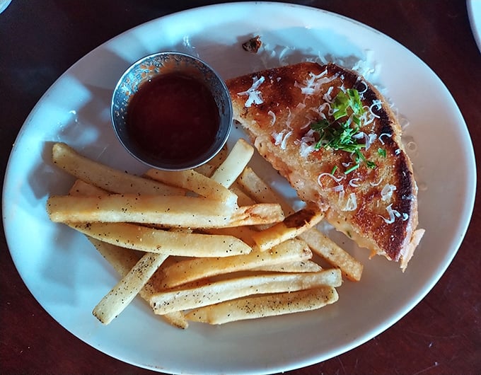 Simplicity elevated to art form – perfectly grilled bread, melty cheese, and those seasoned fries standing at attention, ready for their dipping destiny.