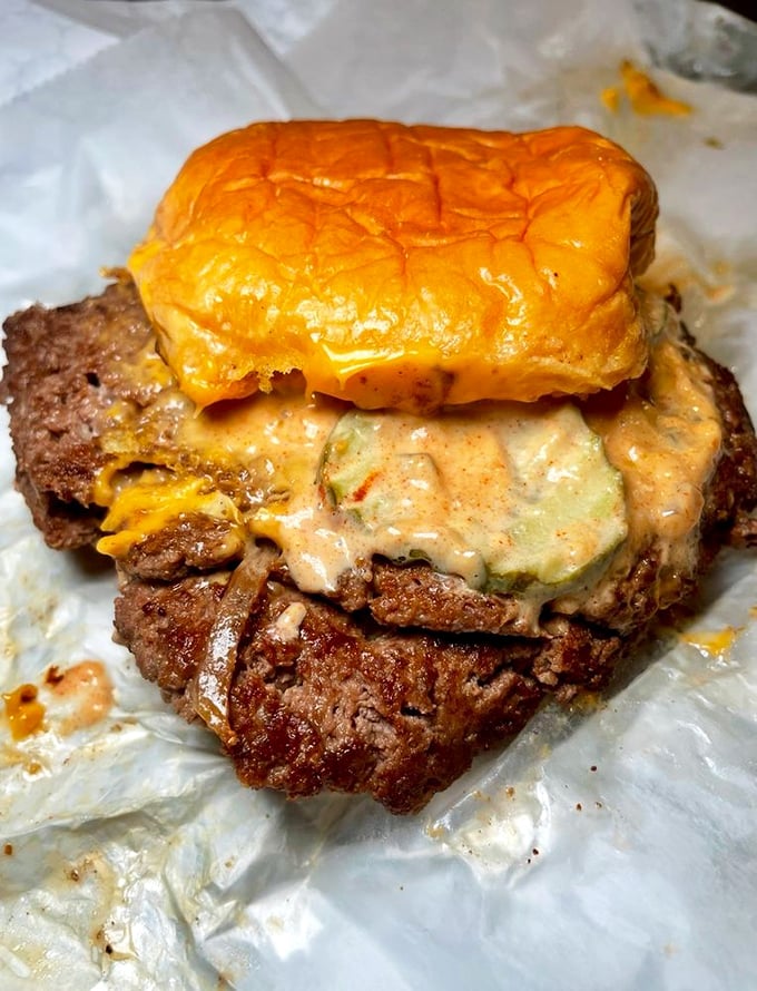 This isn't just a burger—it's a meaty monument to excess, with cheese cascading down the sides like a dairy waterfall of dreams.