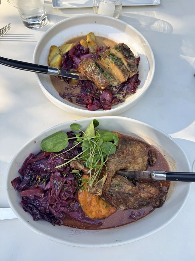 Duck confit nestled on a bed of red cabbage—the meat so tender it practically surrenders to your fork with a Gallic shrug.