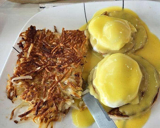 Eggs Benedict done right—perfectly poached eggs nestled on Canadian bacon, draped in hollandaise that cascades like a buttery waterfall.