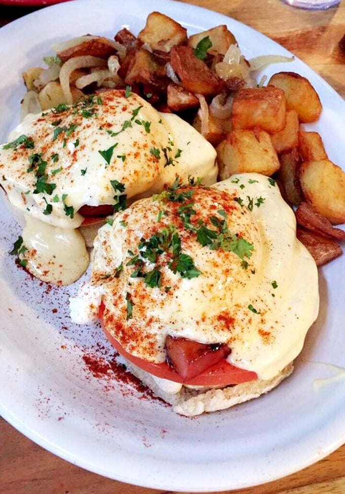 Eggs Benedict reimagined with a sprinkle of paprika and fresh herbs—proof that classics become legendary when executed with this level of care.