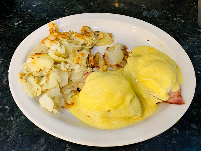 Eggs Benedict that puts the "art" in breakfast artistry – sunshine-yellow hollandaise cascading over Canadian bacon like a morning waterfall.