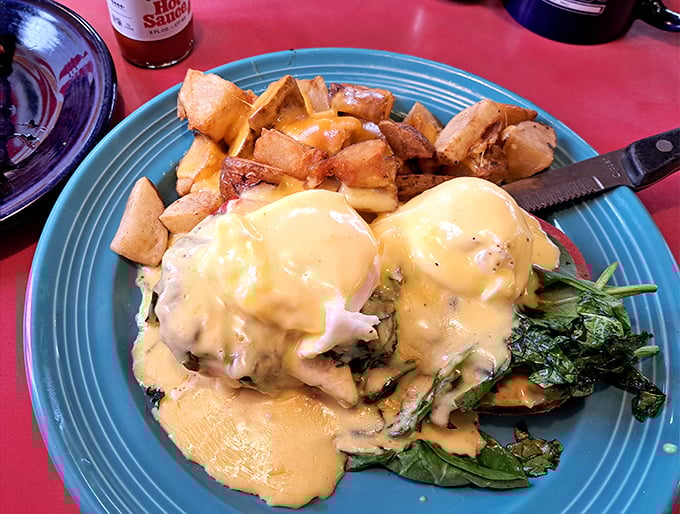 Eggs Benedict reimagined with fresh greens and golden potatoes – a breakfast that demands to be photographed before devoured.