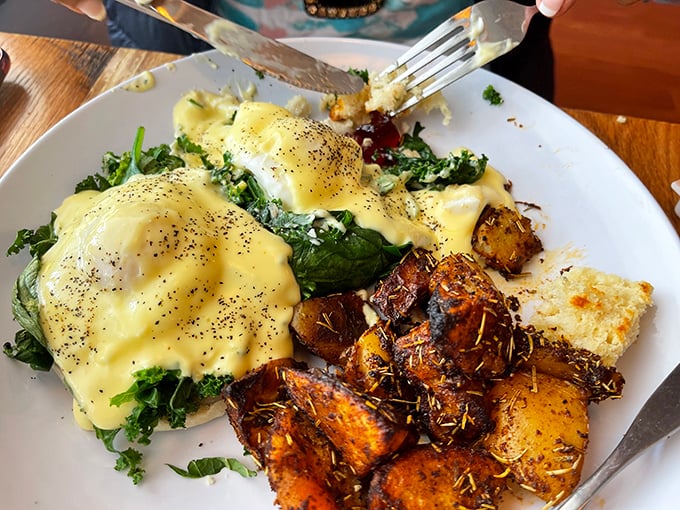 Eggs Benedict reimagined with vibrant greens and herb-roasted potatoes – proof that classics can evolve without losing their soul.