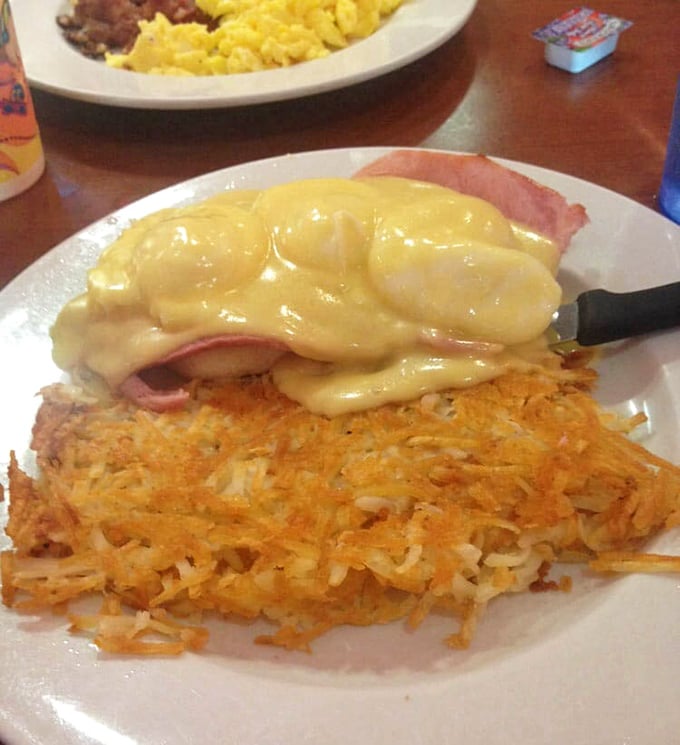 Eggs Benedict reimagined with those impossibly crispy hashbrowns – breakfast architecture that deserves its own HGTV special.