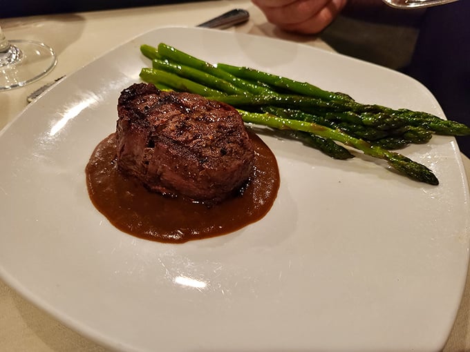 A filet mignon that doesn't need a passport to transport you to heaven, accompanied by asparagus soldiers standing at attention.