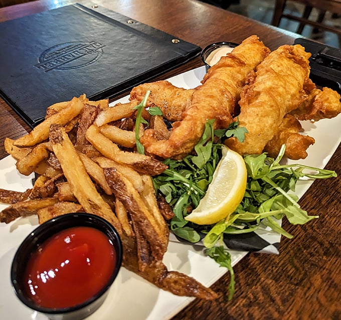 Fish and chips that would make a British pub jealous – golden batter shattering at first bite to reveal flaky white fish beneath.