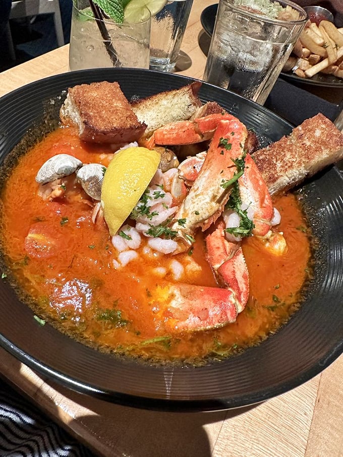 The seafood stew arrives like an edible treasure chest—crimson broth cradling plump shrimp and tender fish with crusty bread standing by for the inevitable dipping frenzy.