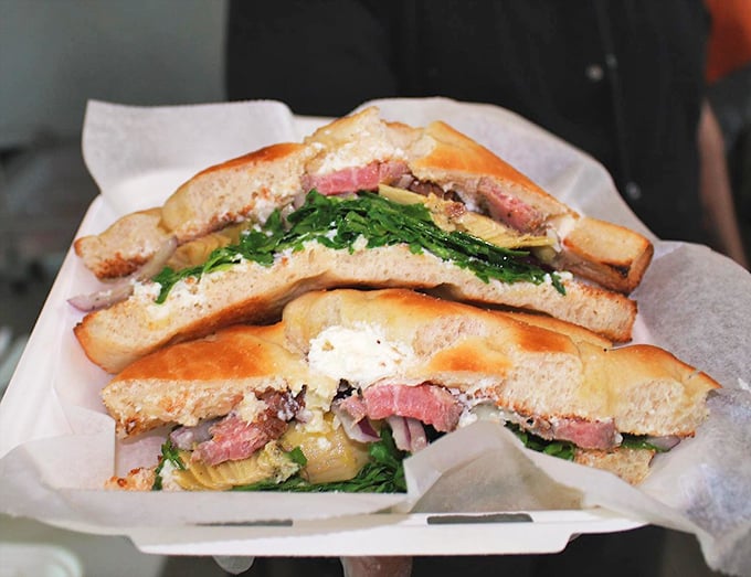 This isn't just a sandwich; it's a masterpiece of balance – crusty bread, tender meat, and vibrant greens creating the holy trinity of handheld perfection.