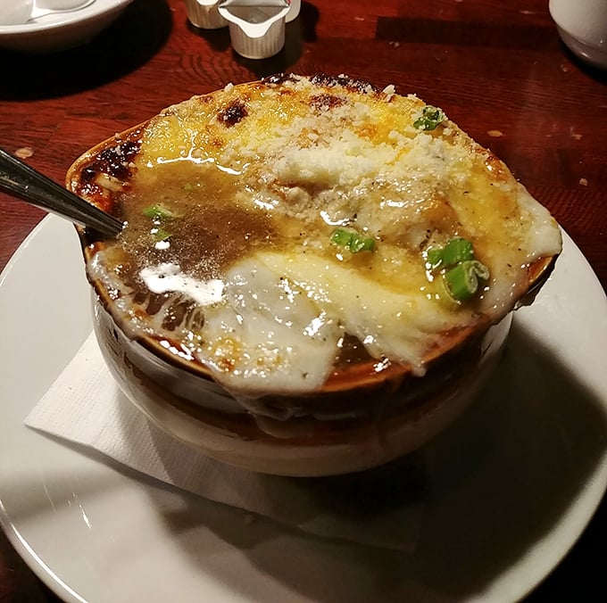 Bubbling cheese creates the perfect golden canopy over this French onion soup. It's not just a starter—it's a warm hug in a ceramic crock.