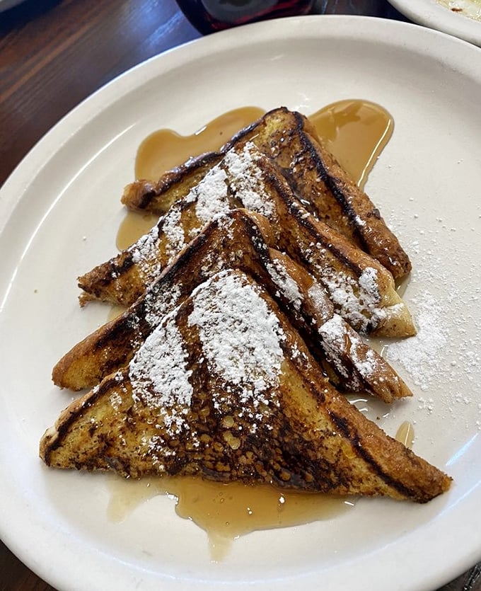 French toast dusted with powdered sugar and swimming in maple syrup—proof that bread can indeed achieve its highest purpose in life.