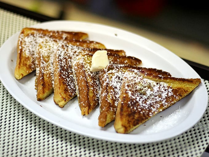 French toast arranged with military precision, dusted with powdered sugar like the first perfect snowfall of winter.