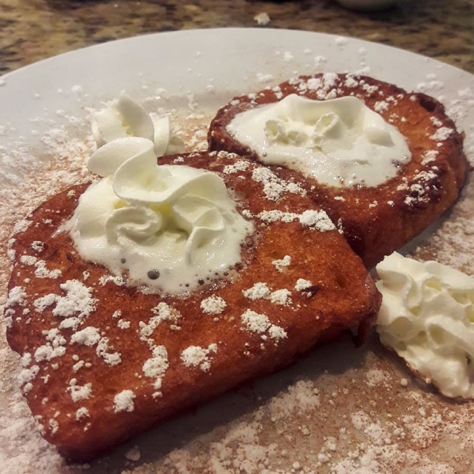 French toast that makes you question all other French toast you've ever had. Those dollops of whipped cream aren't just garnish—they're little clouds of joy.