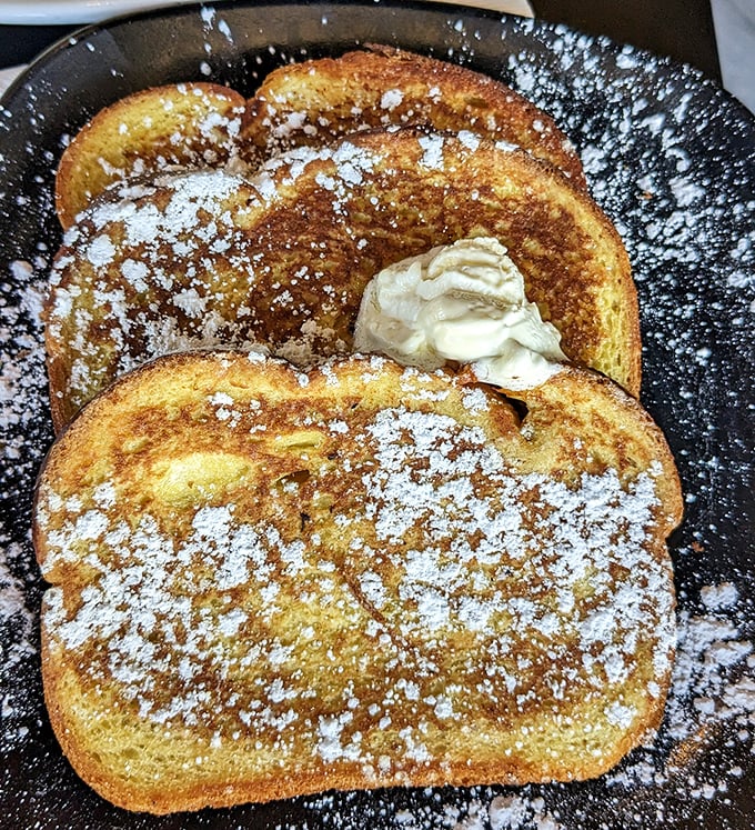 Golden-brown French toast dusted with powdered sugar – proof that bread can achieve greatness with just a little egg bath.