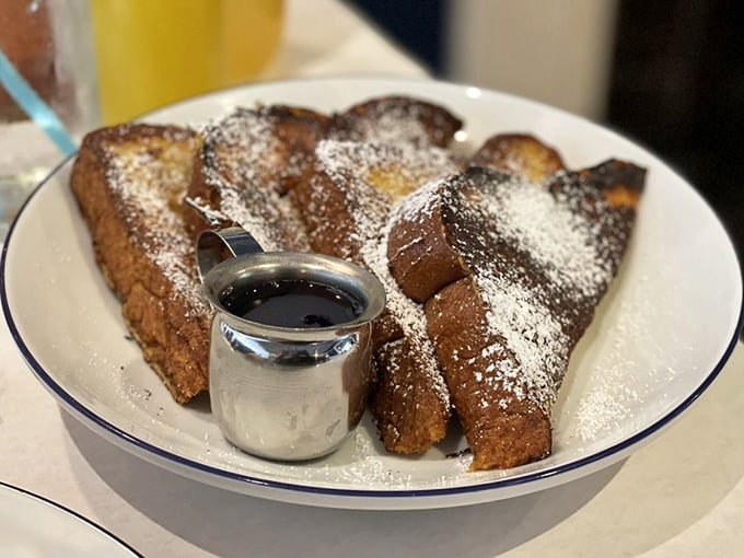 French toast that's dressed for success—powdered sugar "snow" falling on golden-brown landscape with a silver pot of syrup standing by for the finishing touch.
