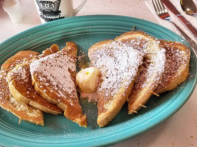 This French toast doesn't just wear its powdered sugar like a winter coat—it practically demands you cancel all afternoon plans.