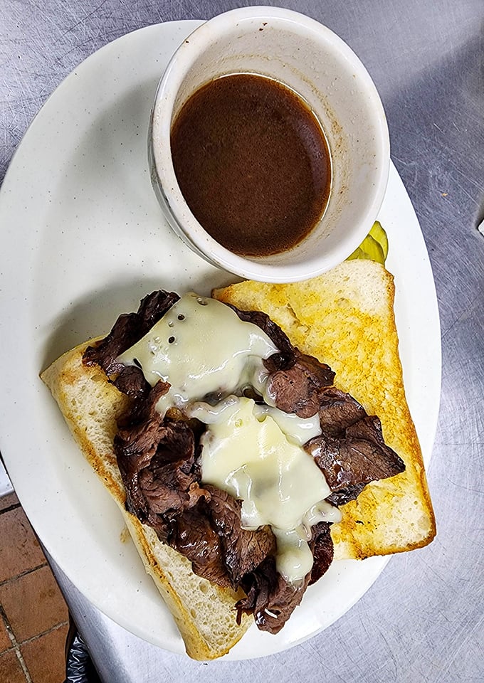 This open-faced sandwich isn't just lunch—it's a masterpiece of tender beef, melted cheese, and savory au jus for dunking.