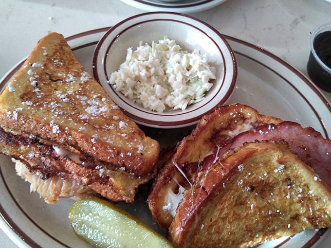 Golden-brown French toast that's achieved that mythical balance – crispy edges, custardy center, and enough powdered sugar to leave evidence on your shirt.