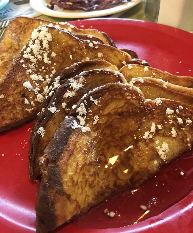Golden-brown French toast dusted with powdered sugar—proof that bread's highest calling was never meant to be a sandwich.