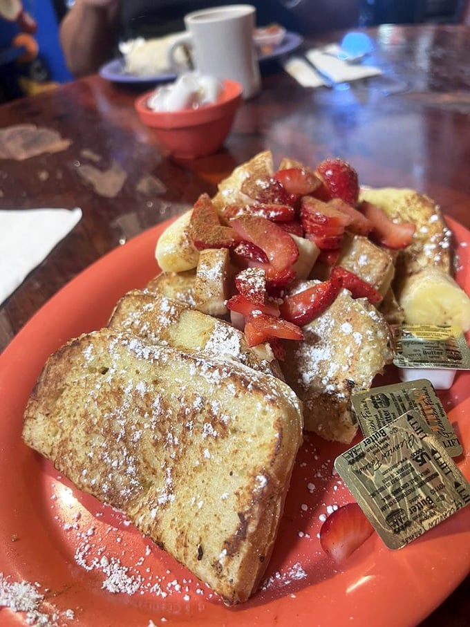 French toast that deserves its own passport—golden, crispy edges surrounding custardy centers, topped with fresh berries and a dusting of powdered sugar.
