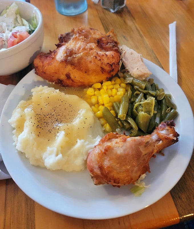 Fried chicken so perfectly golden it deserves its own trophy, accompanied by the holy trinity of Midwestern sides—mashed potatoes, corn, and green beans.
