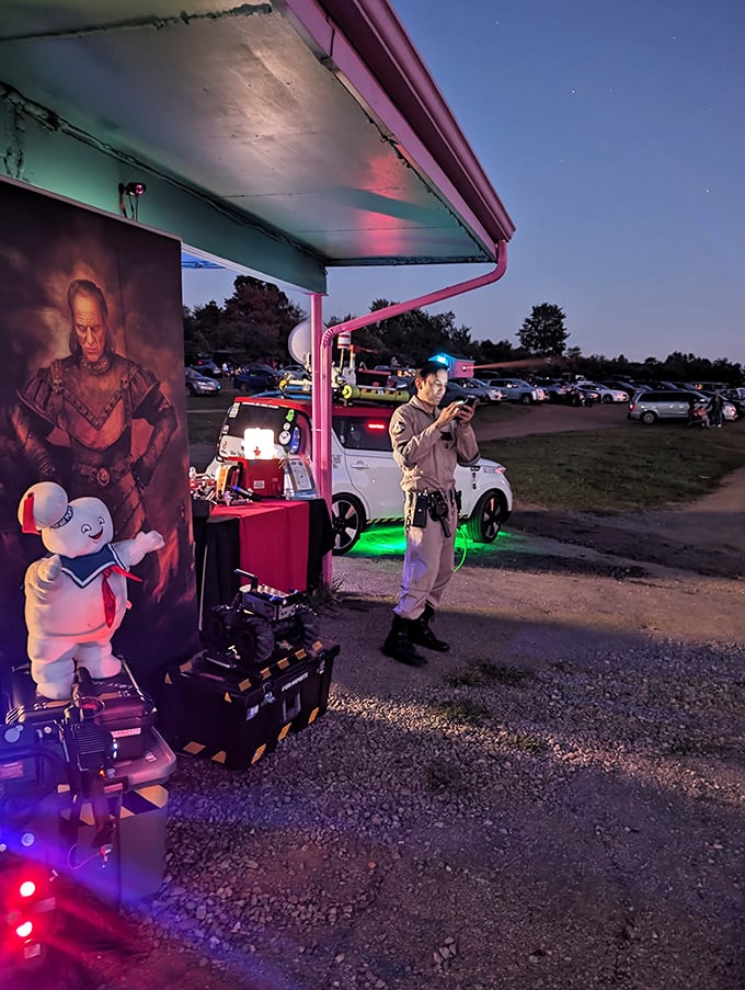 Where nostalgia meets modern entertainment—a costumed figure stands guard while patrons navigate between fantasy worlds and concession stands.