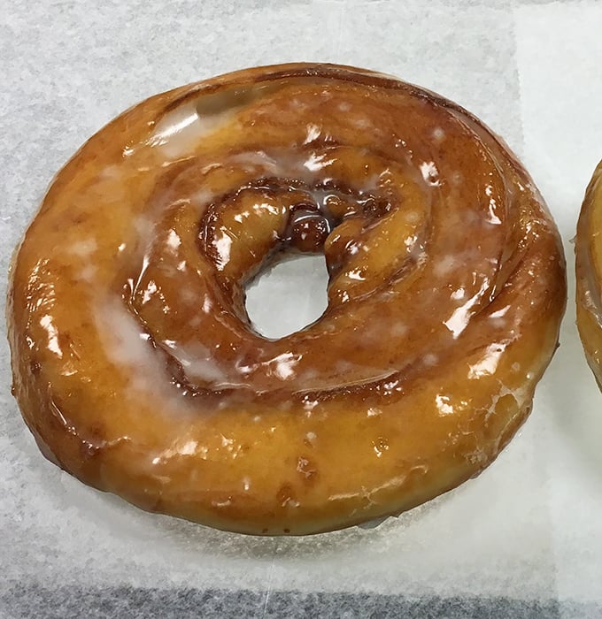 The platonic ideal of a glazed doughnut – that perfect amber sheen catching the light like a sugary stained glass window.