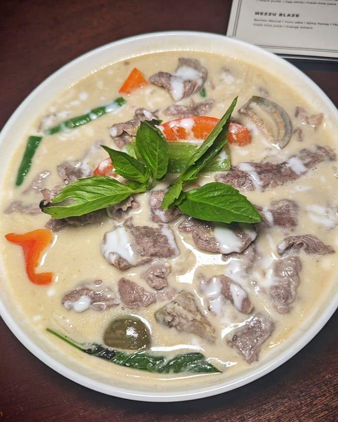 This green curry doesn't just bring the heat; it tells a story with each spoonful, the fresh basil leaves acting as exclamation points.