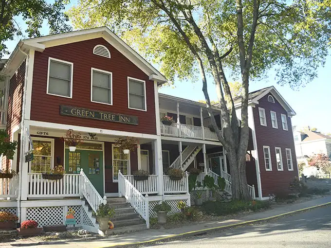 The Green Tree Inn stands proudly in its crimson glory, offering weary travelers what chain hotels can't—authentic character and homemade breakfast.