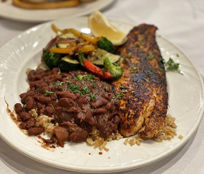 Blackened fish perfection atop rice with red beans and sautéed vegetables—proof that healthy eating and flavor aren't mutually exclusive concepts.