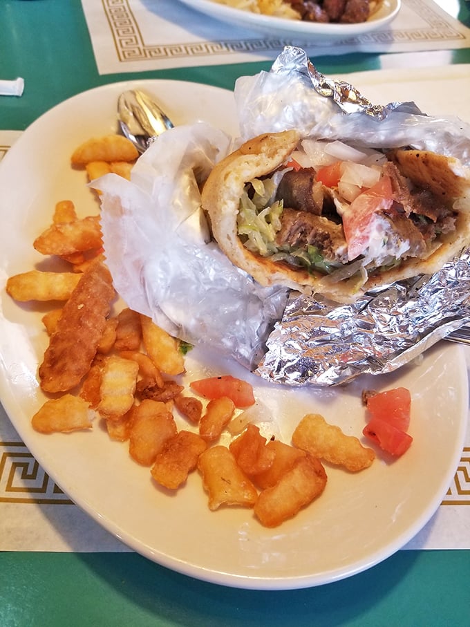 This gyro wrapped in foil isn't trying to win beauty contests—it's too busy delivering Mediterranean flavors alongside perfectly crispy home fries.